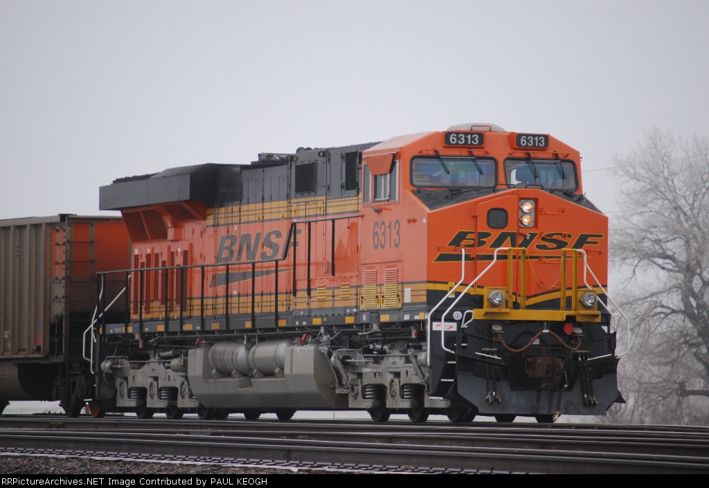 BNSF 6313 rolls west towards the entrance to the coal mines north of Gillette, Wy as a rear DPU ...
